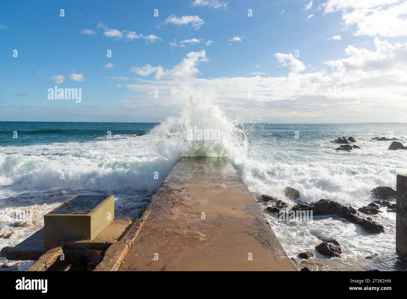 Sea wave crashing hard on a beach pier. Wild nature Stock Photo - Alamy