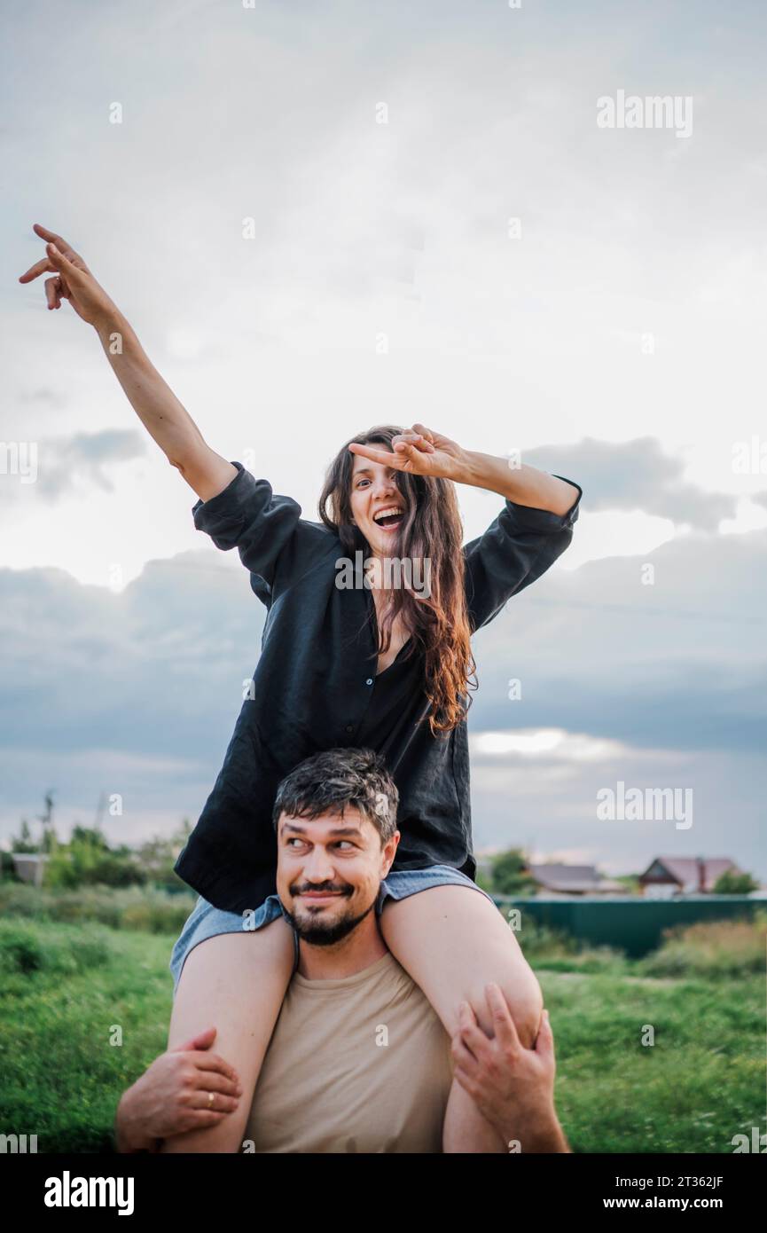 Happy man carrying woman on shoulders in the countryside Stock Photo ...