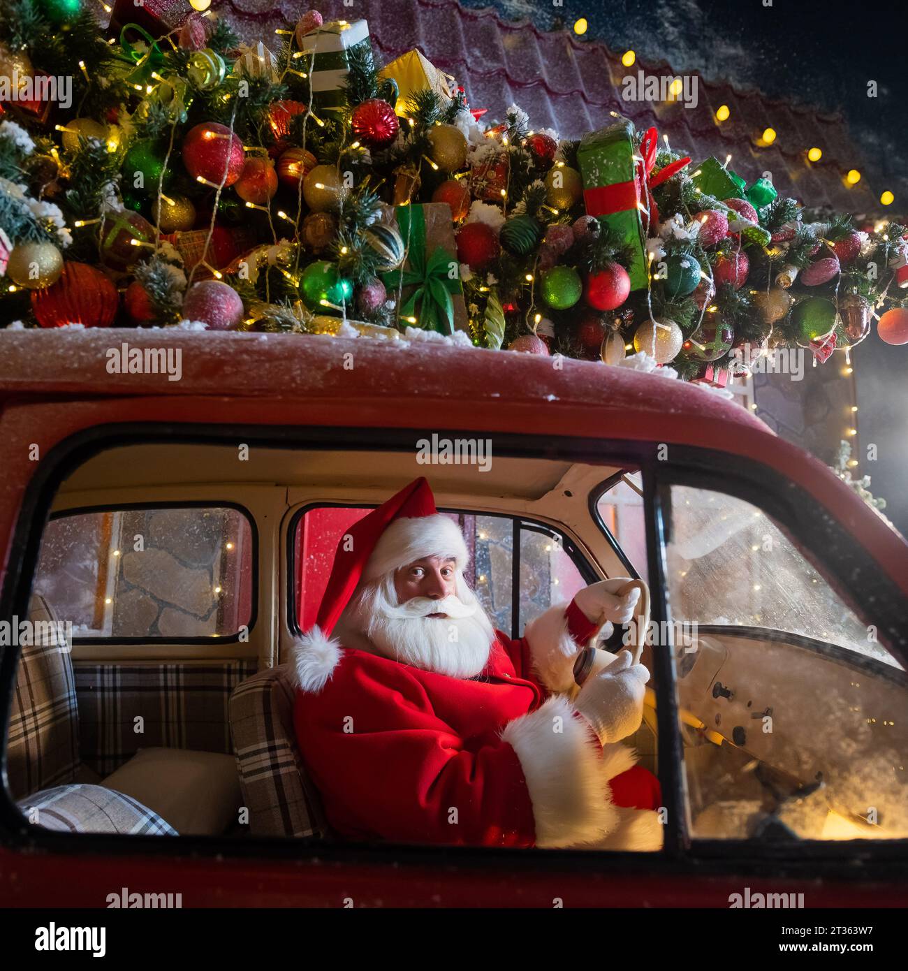 Portrait of santa claus driving a car loaded with a Christmas tree and ...
