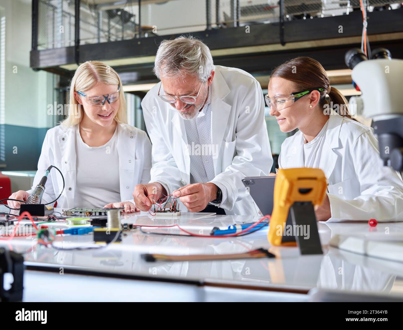 Professor teaching trainees with circuit board in laboratory Stock ...