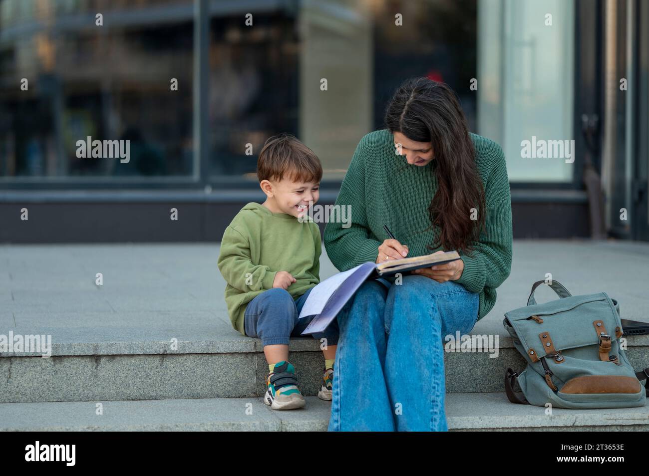 Happy boy with mother writing in diary on steps Stock Photo - Alamy