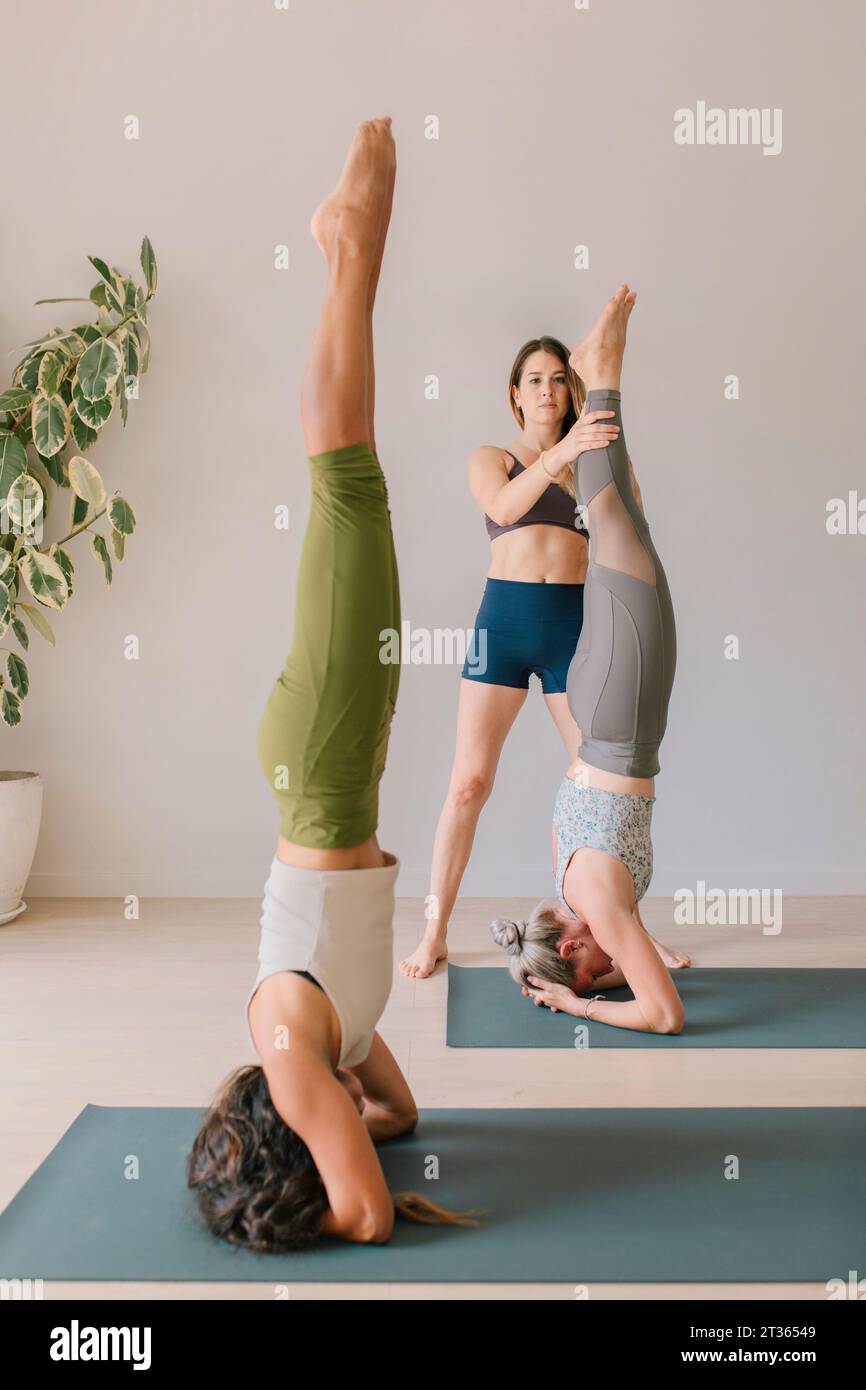 Yoga instructor teaching women at studio Stock Photo - Alamy