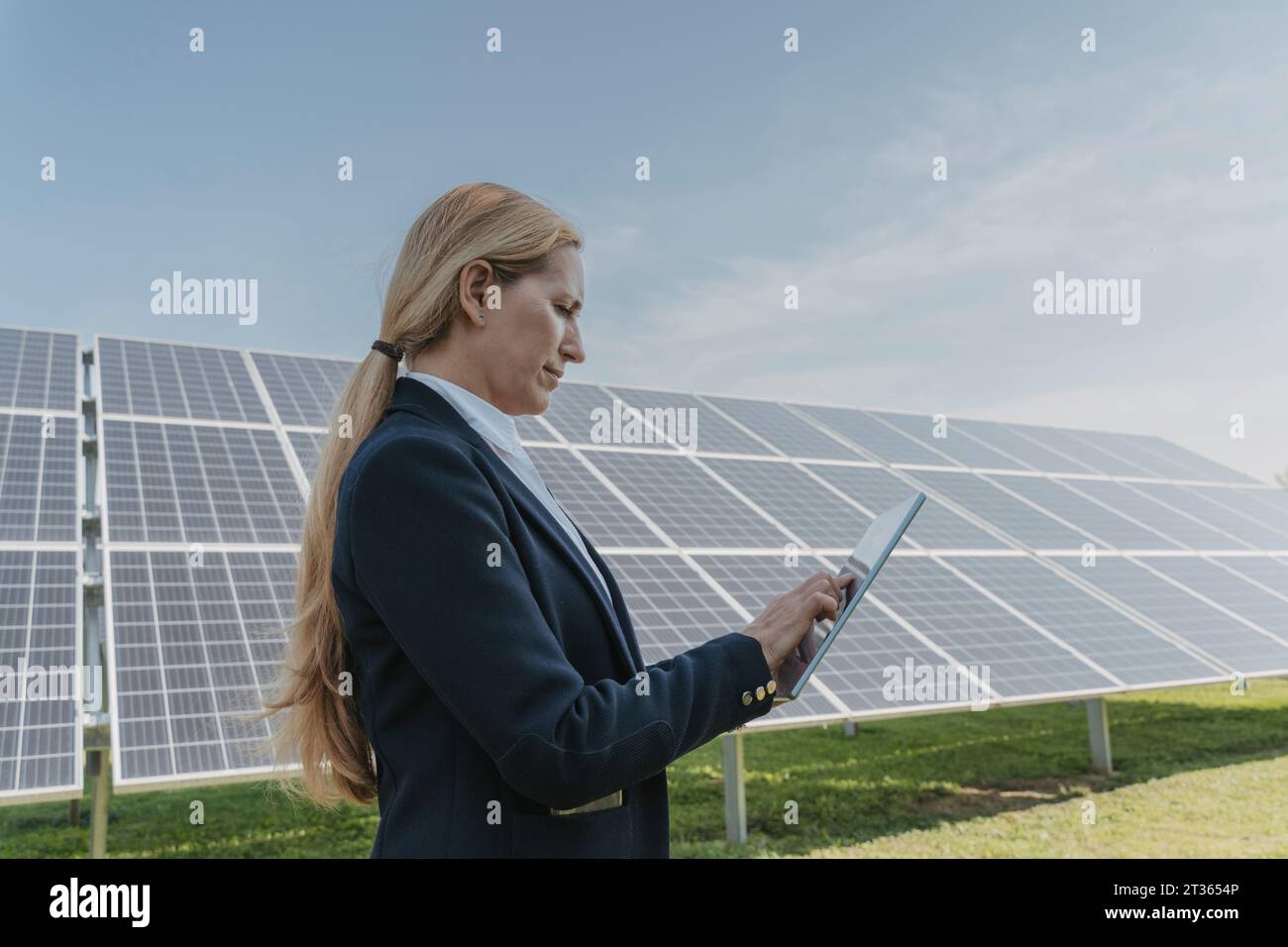 Engineer using tablet PC in front of solar panels Stock Photo - Alamy