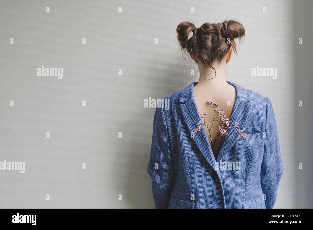Teenage girl wearing blue blazer backwards with flowers on her back ...
