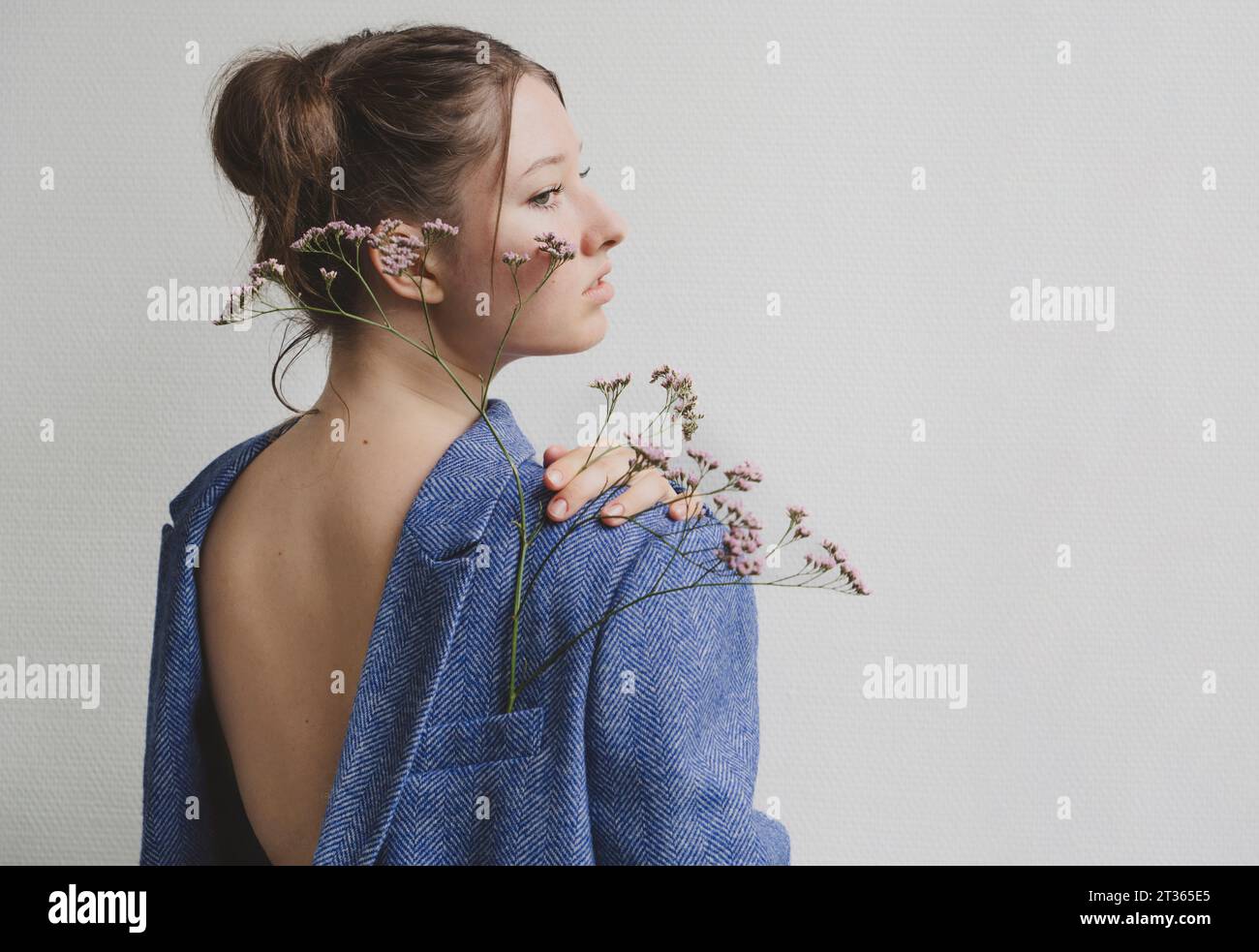 Teenage girl wearing blue blazer backwards with flowers in pocket by ...