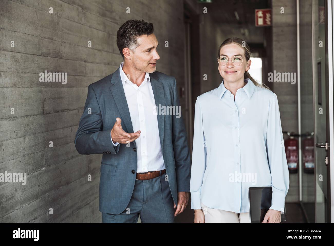 Smiling businessman and businesswoman having discussion together in ...