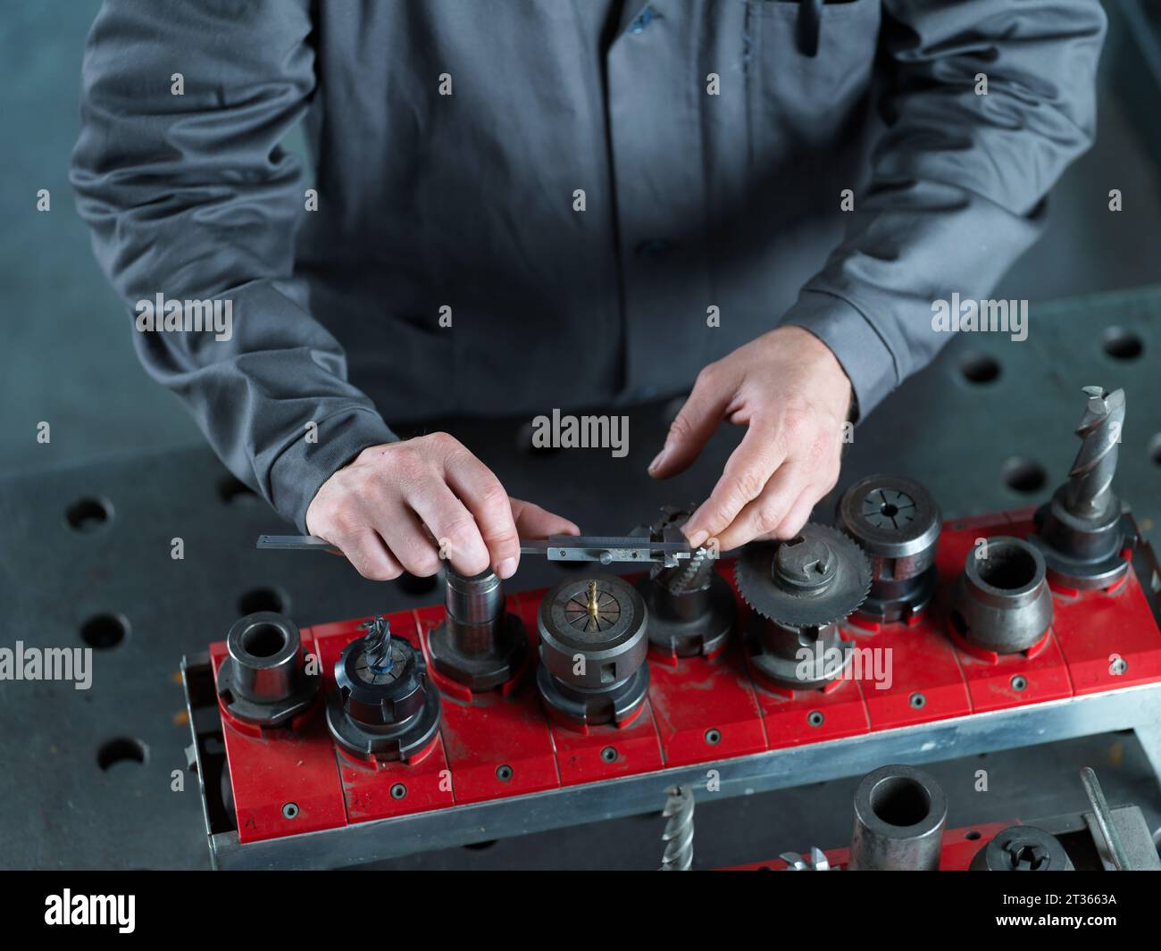 Metal worker checking CNC tool with caliper in factory Stock Photo - Alamy