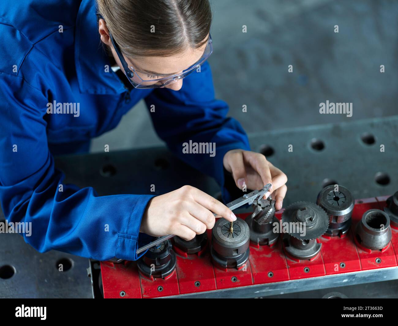 Metal worker measuring CNC tool with caliper in factory Stock Photo - Alamy