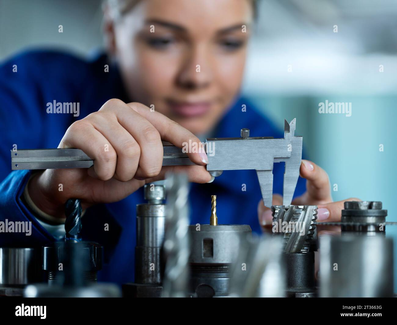Trainee measuring CNC tool with caliper in factory Stock Photo - Alamy