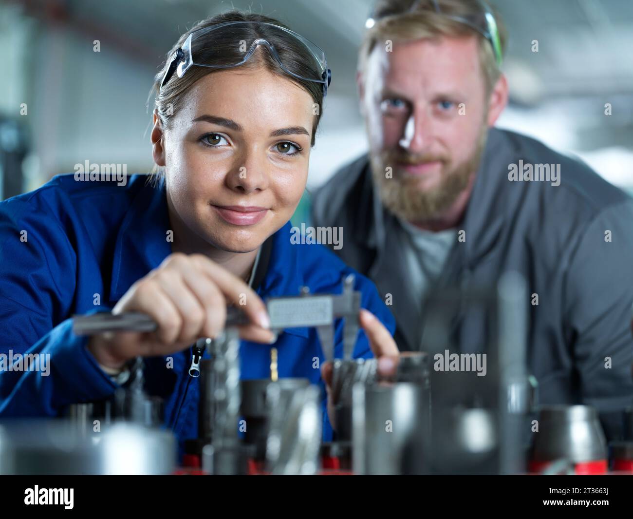 Industry worker with trainee measuring CNC tool in factory Stock Photo ...