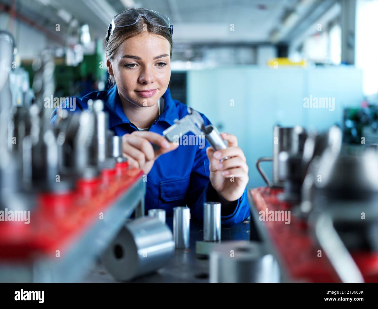 Smiling blue-collar worker checking CNC tool in factory Stock Photo - Alamy