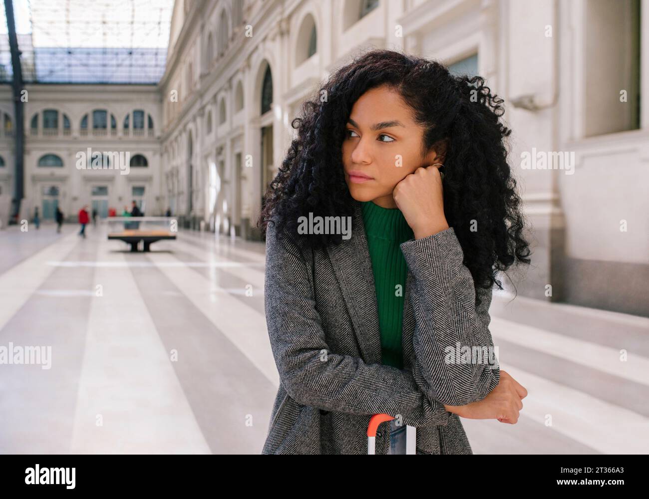 Thoughtful woman leaning on elbow at station Stock Photo - Alamy