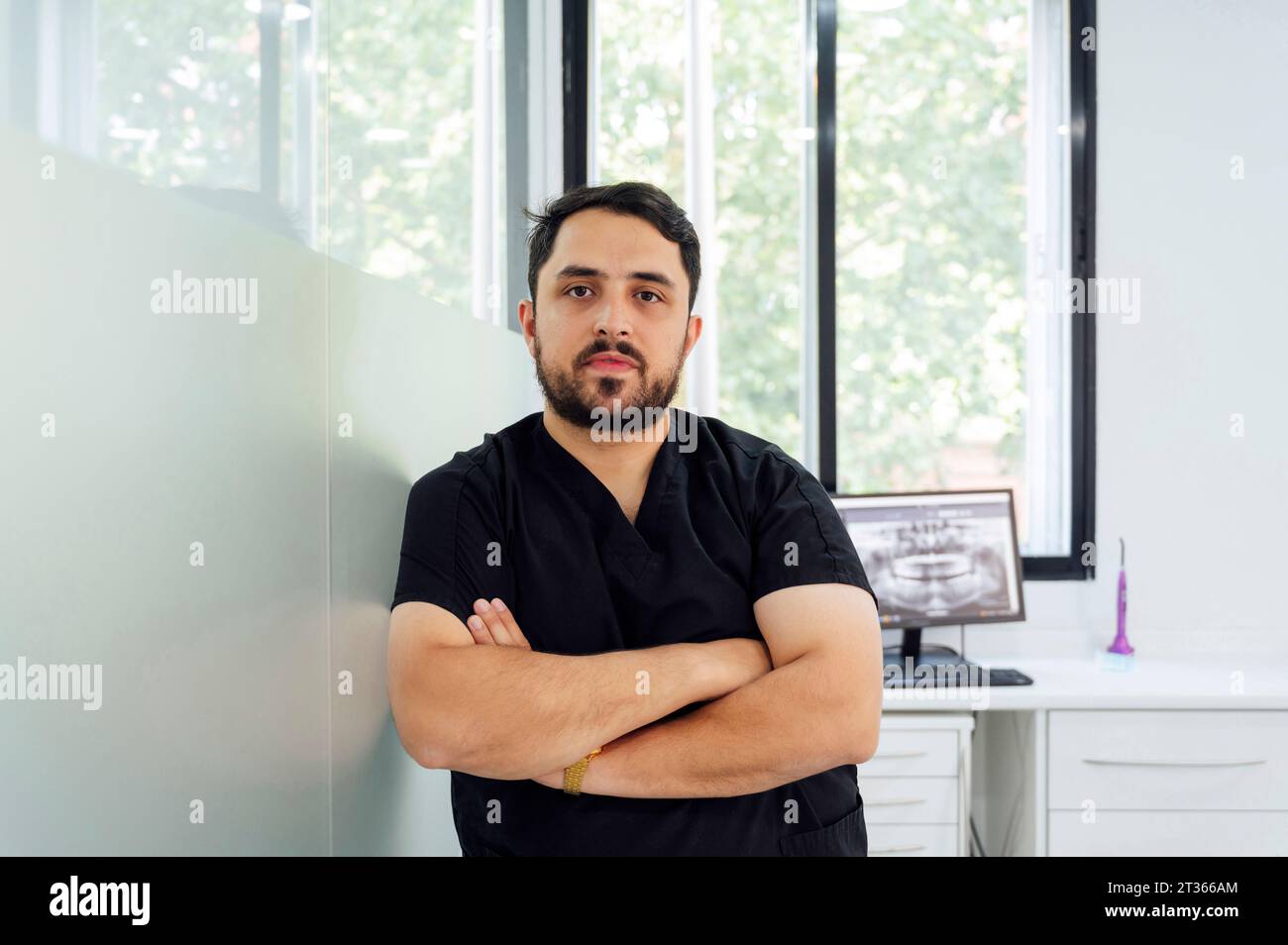 Confident dentist with arms crossed standing in clinic Stock Photo - Alamy