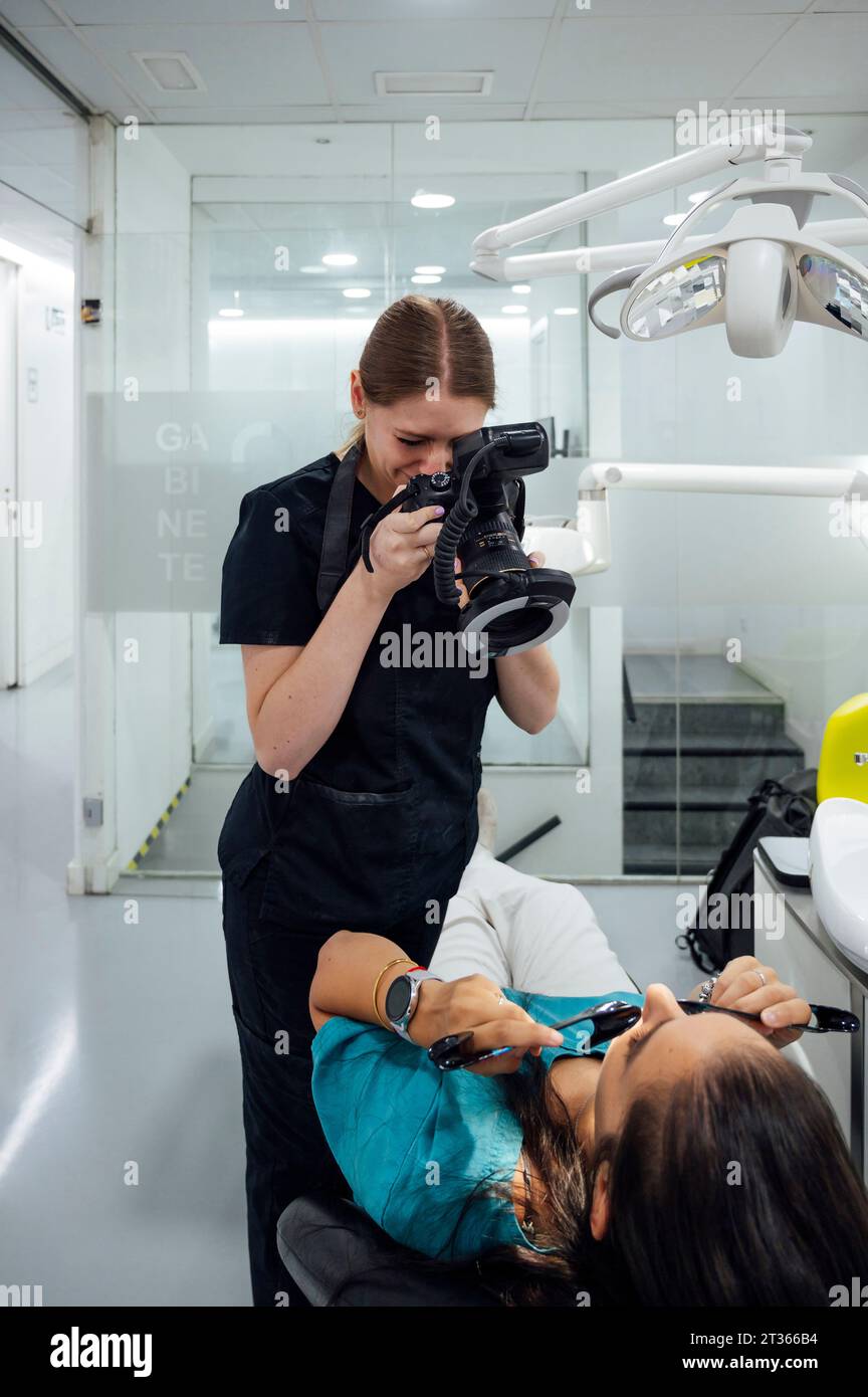 Orthodontist examining patient's teeth through microscope in ...
