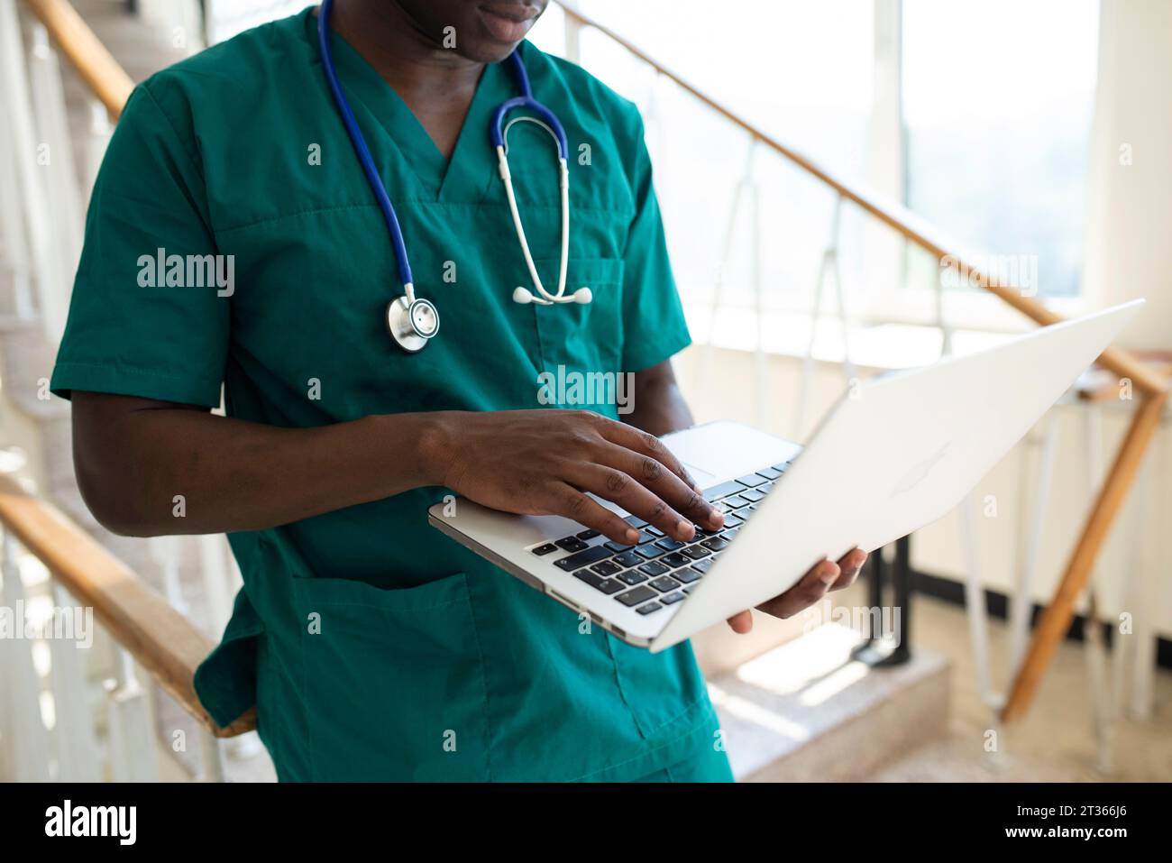 Medical student using laptop by staircase in hospital Stock Photo - Alamy