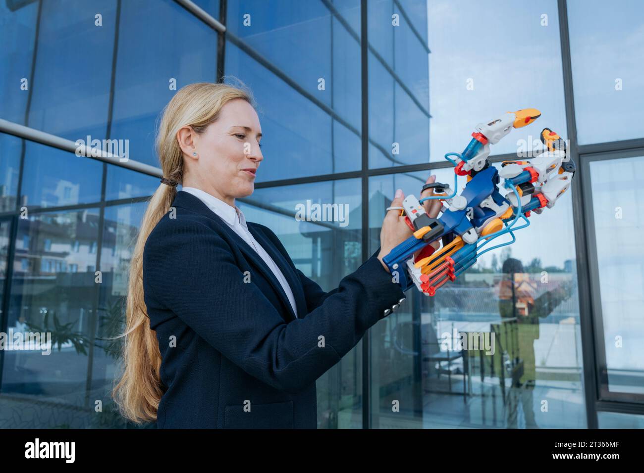 Female architect holding robotic arm near office building Stock Photo ...