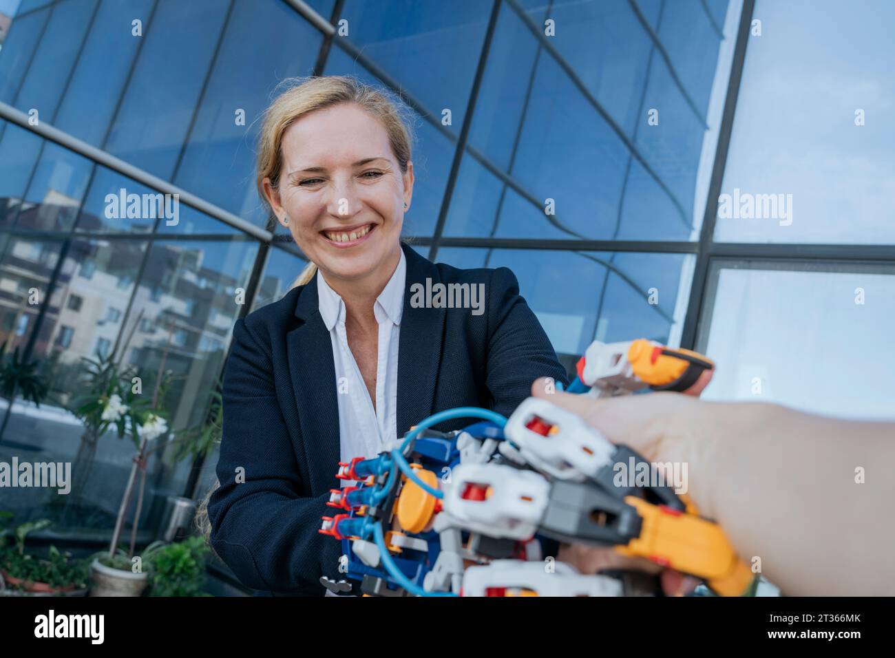 Happy architect looking at robotic arm near office building Stock Photo ...