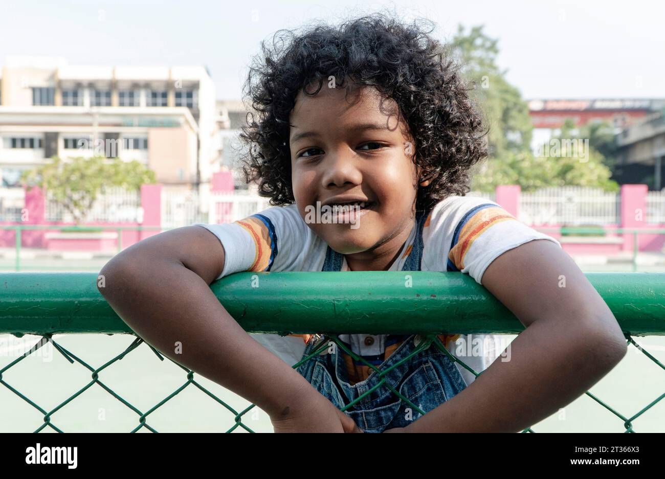 Boy leaning on fence hi-res stock photography and images - Alamy