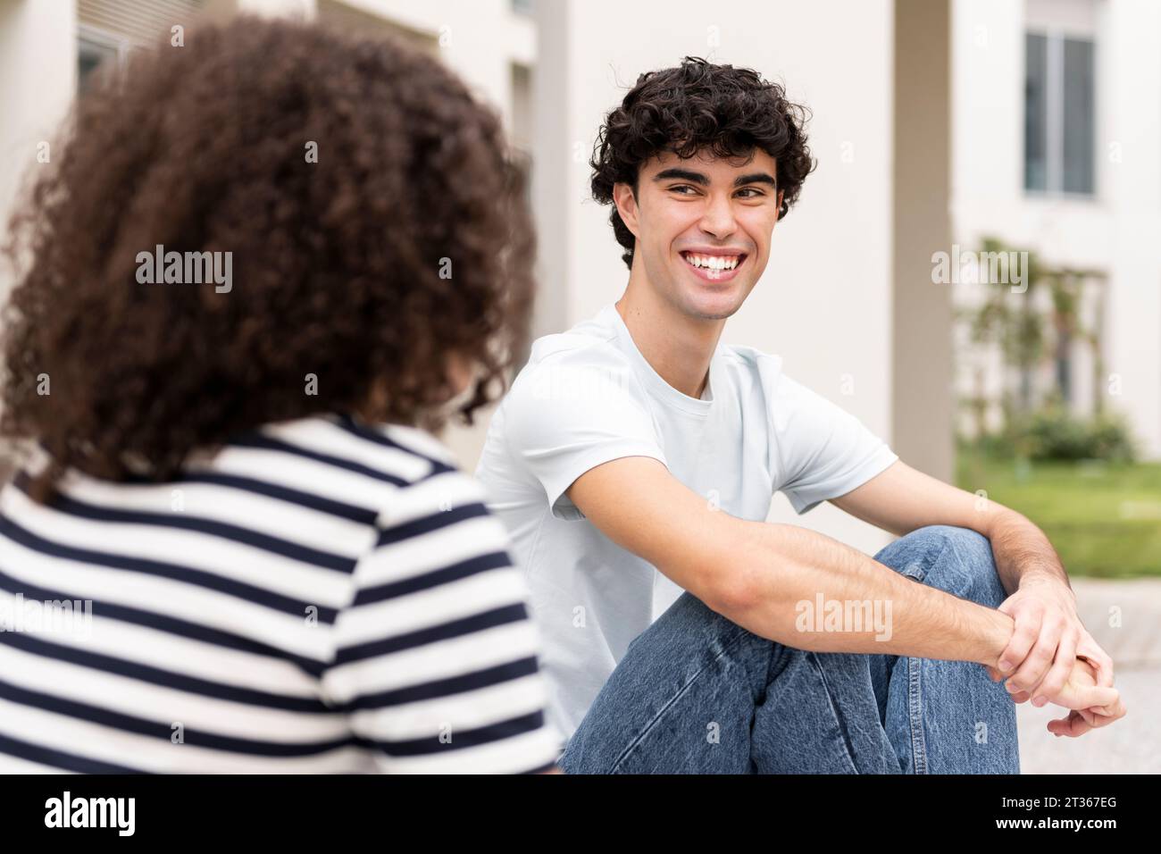 Smiling student talking to friend in campus Stock Photo - Alamy