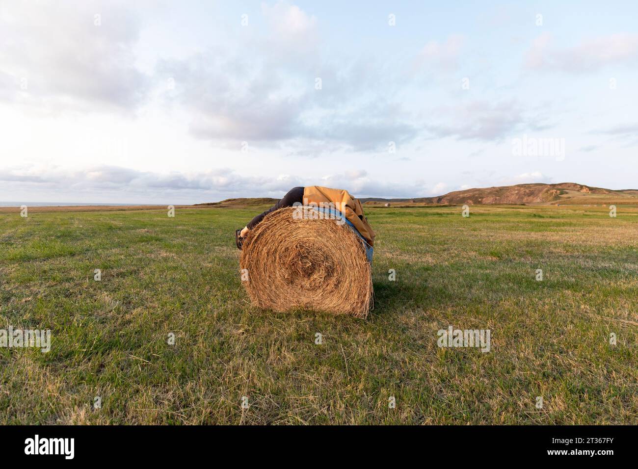 Woman lying on hay in field Stock Photo - Alamy