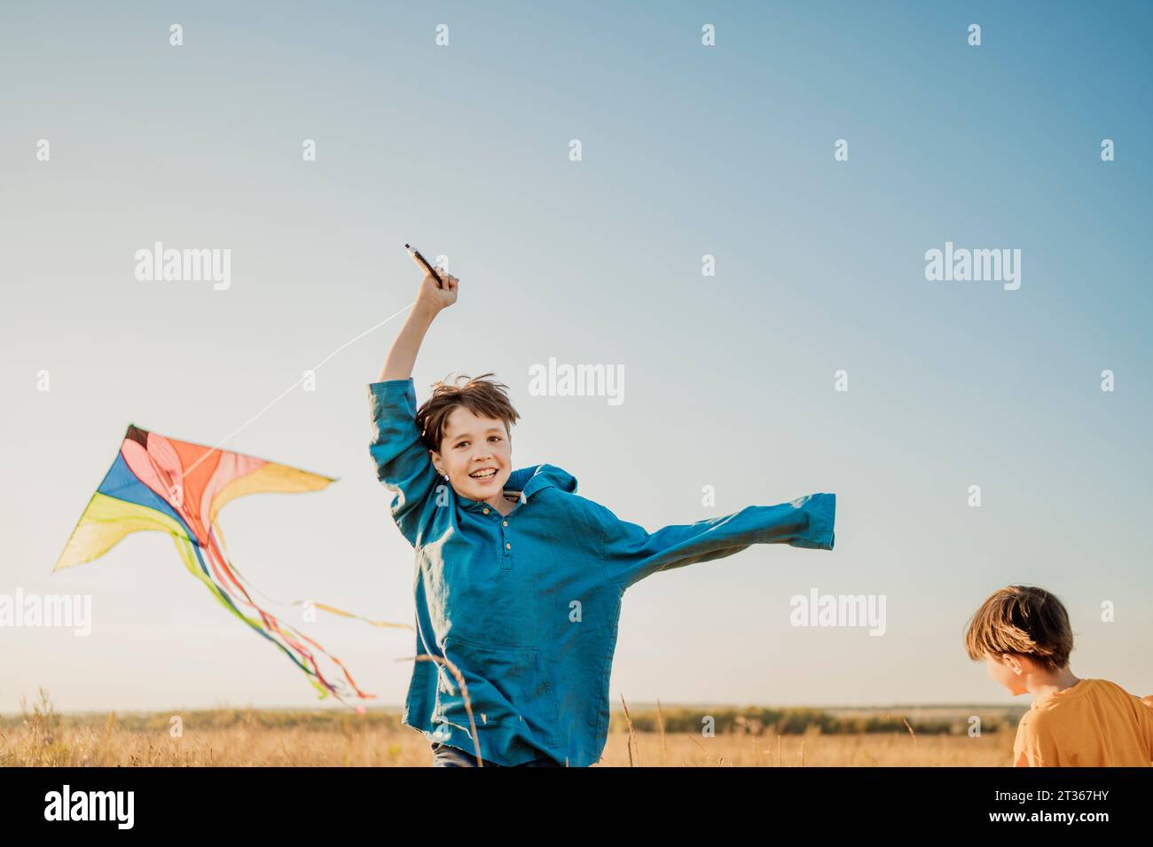 Happy boy flying kite under sky Stock Photo - Alamy