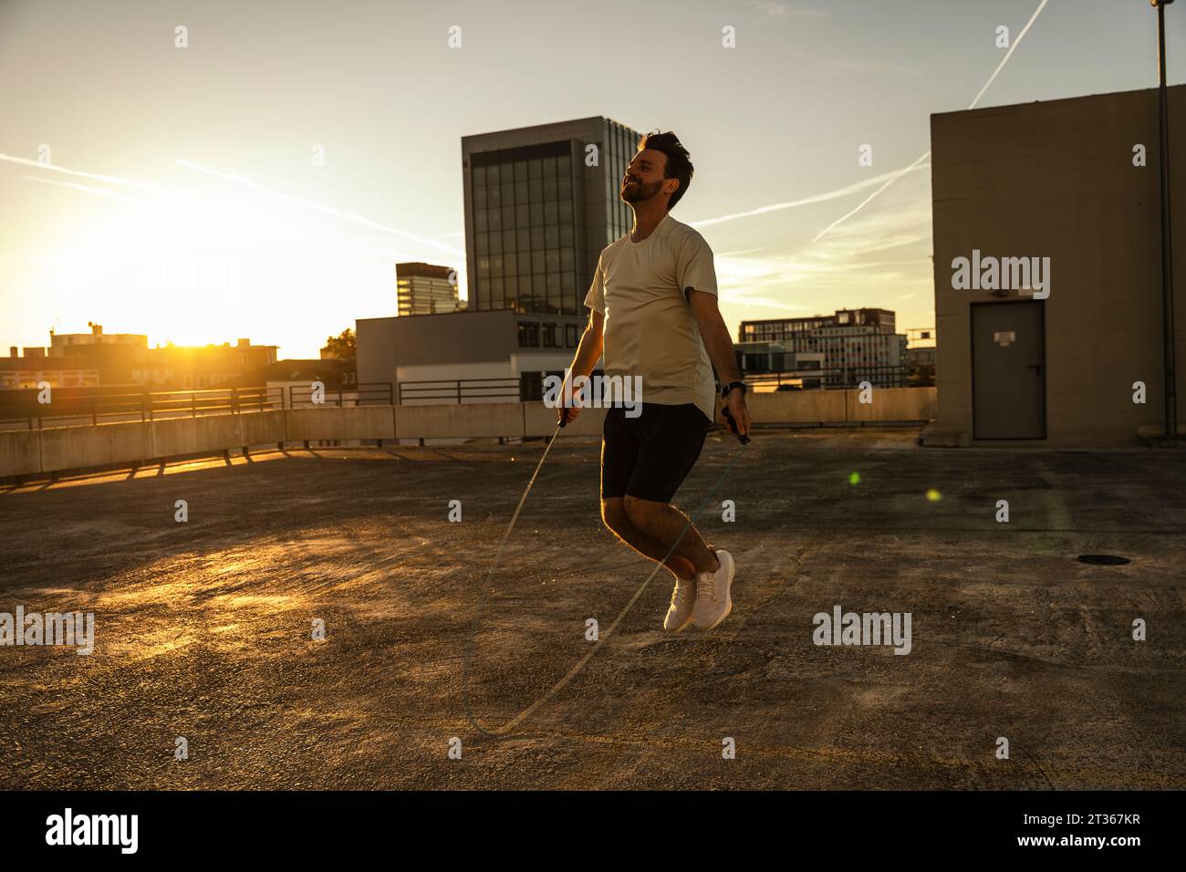Man jumping over rope at terrace Stock Photo - Alamy