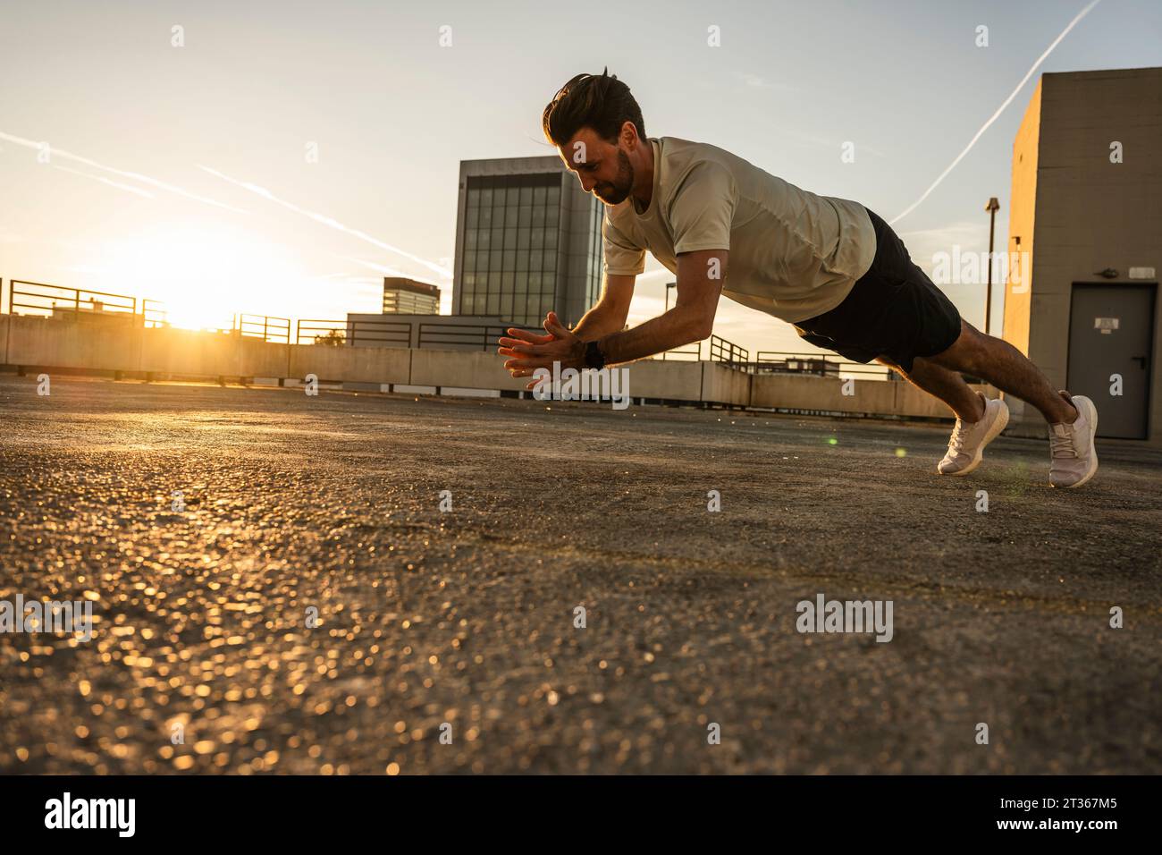 Active man doing push-ups on building terrace at sunset Stock Photo - Alamy