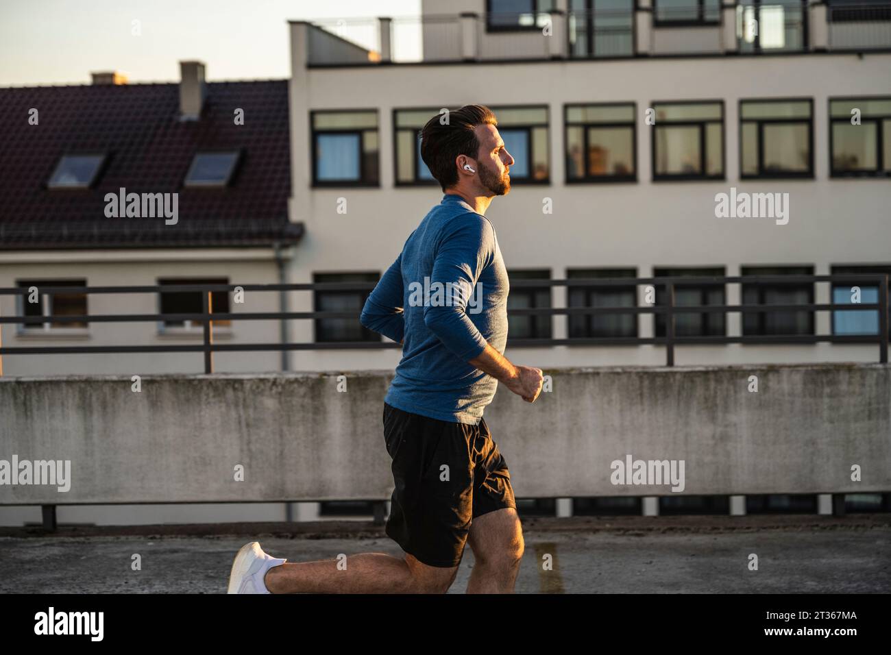 Active man running on terrace at sunset Stock Photo - Alamy
