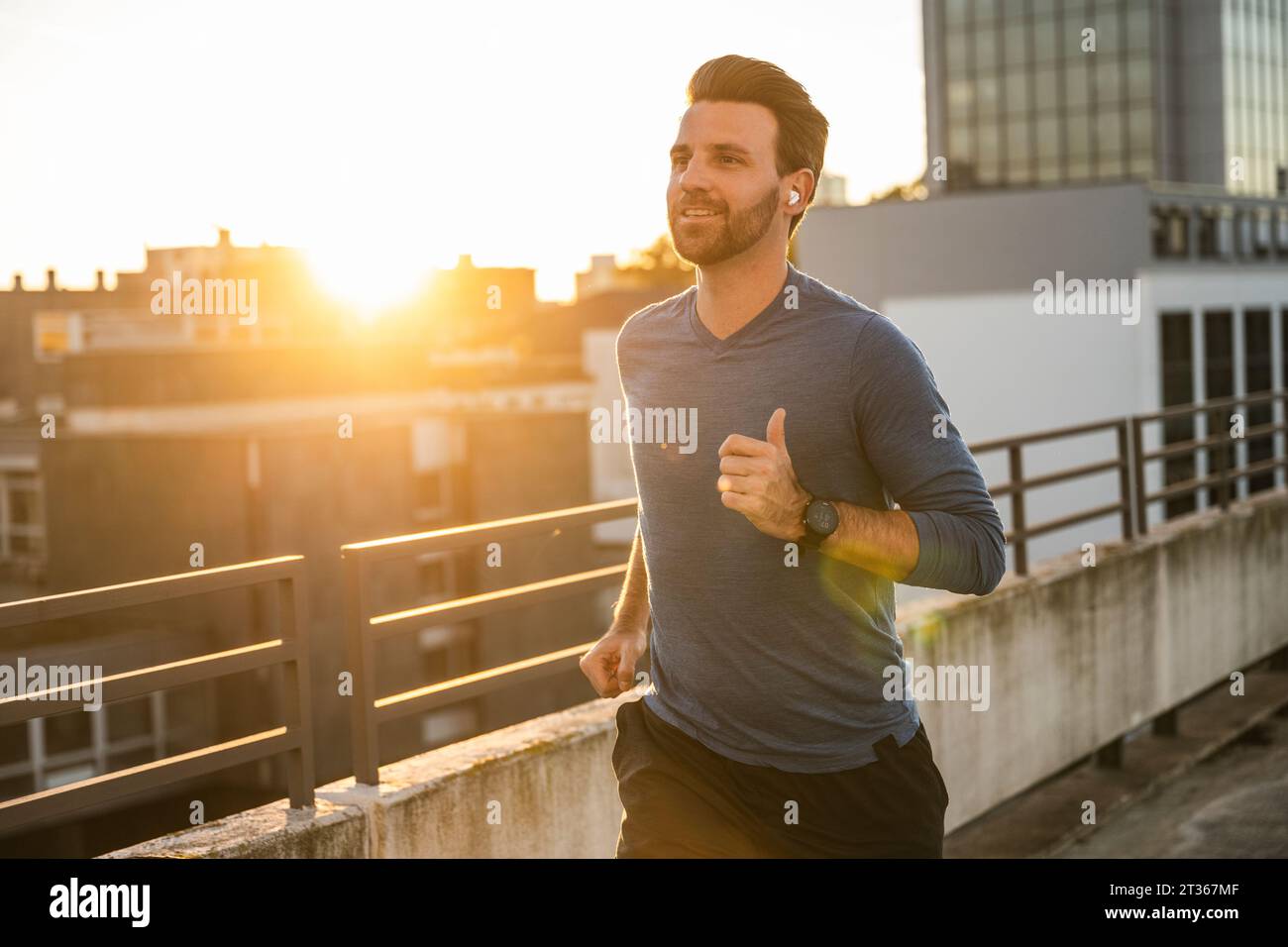 Active man running by railing on terrace at sunset Stock Photo - Alamy