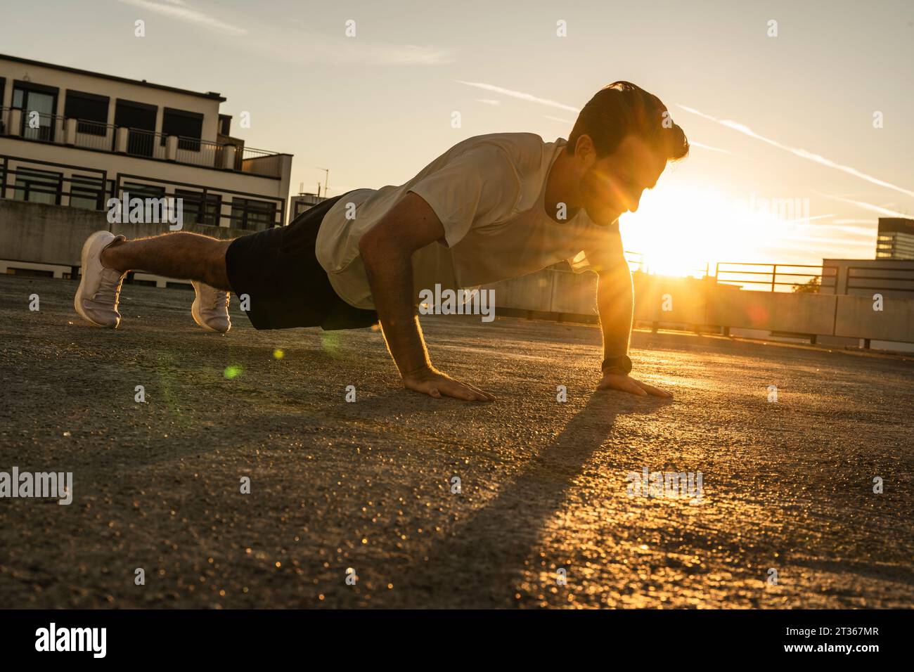 Back lit man doing push-ups on terrace at sunset Stock Photo - Alamy