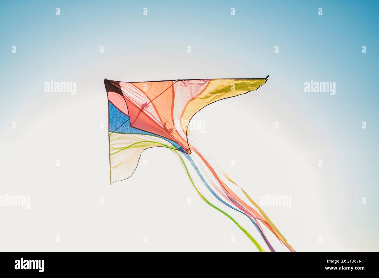 Multi colored kite flying under sky Stock Photo - Alamy