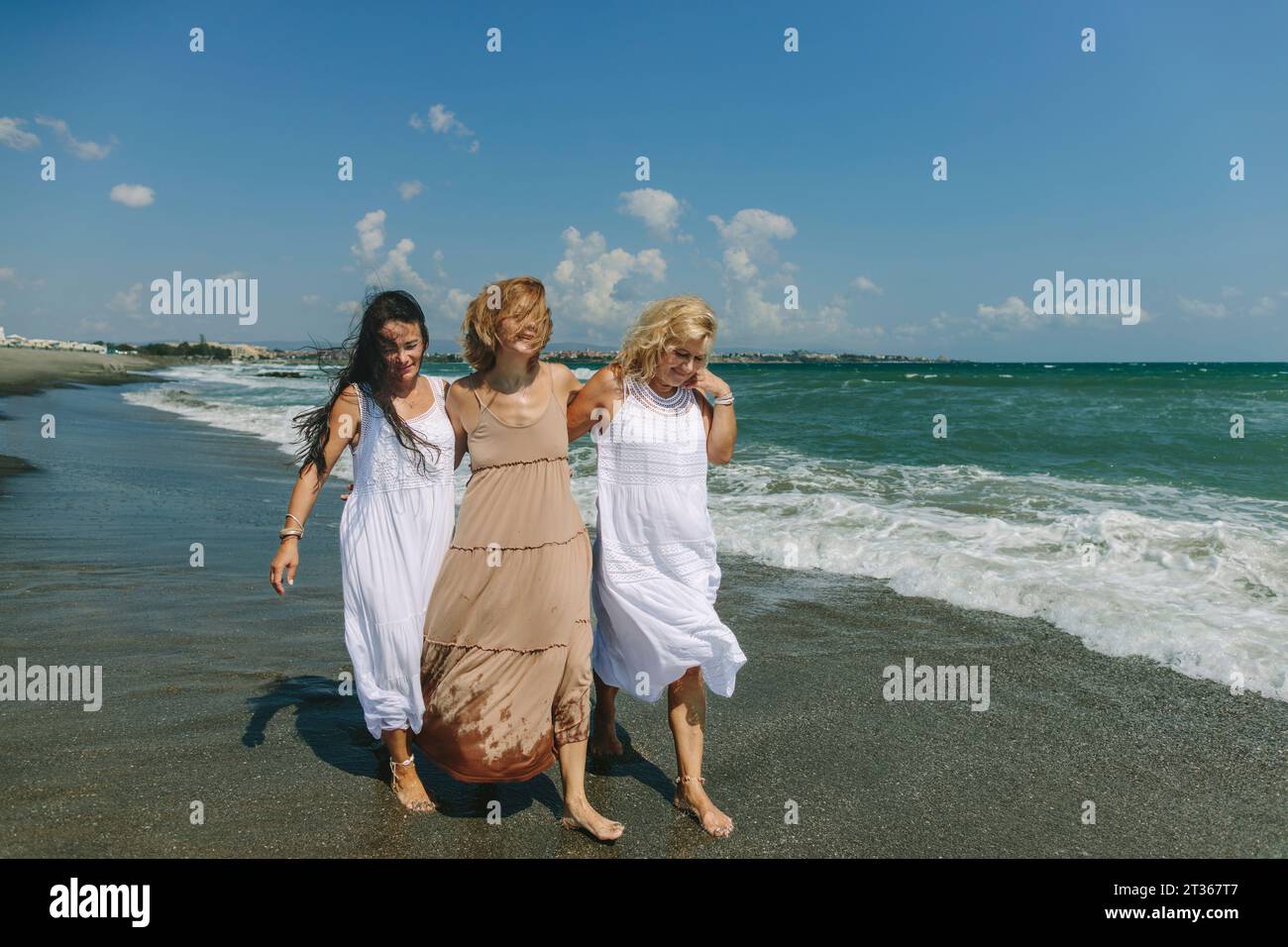 Women walking together near shore at beach Stock Photo - Alamy