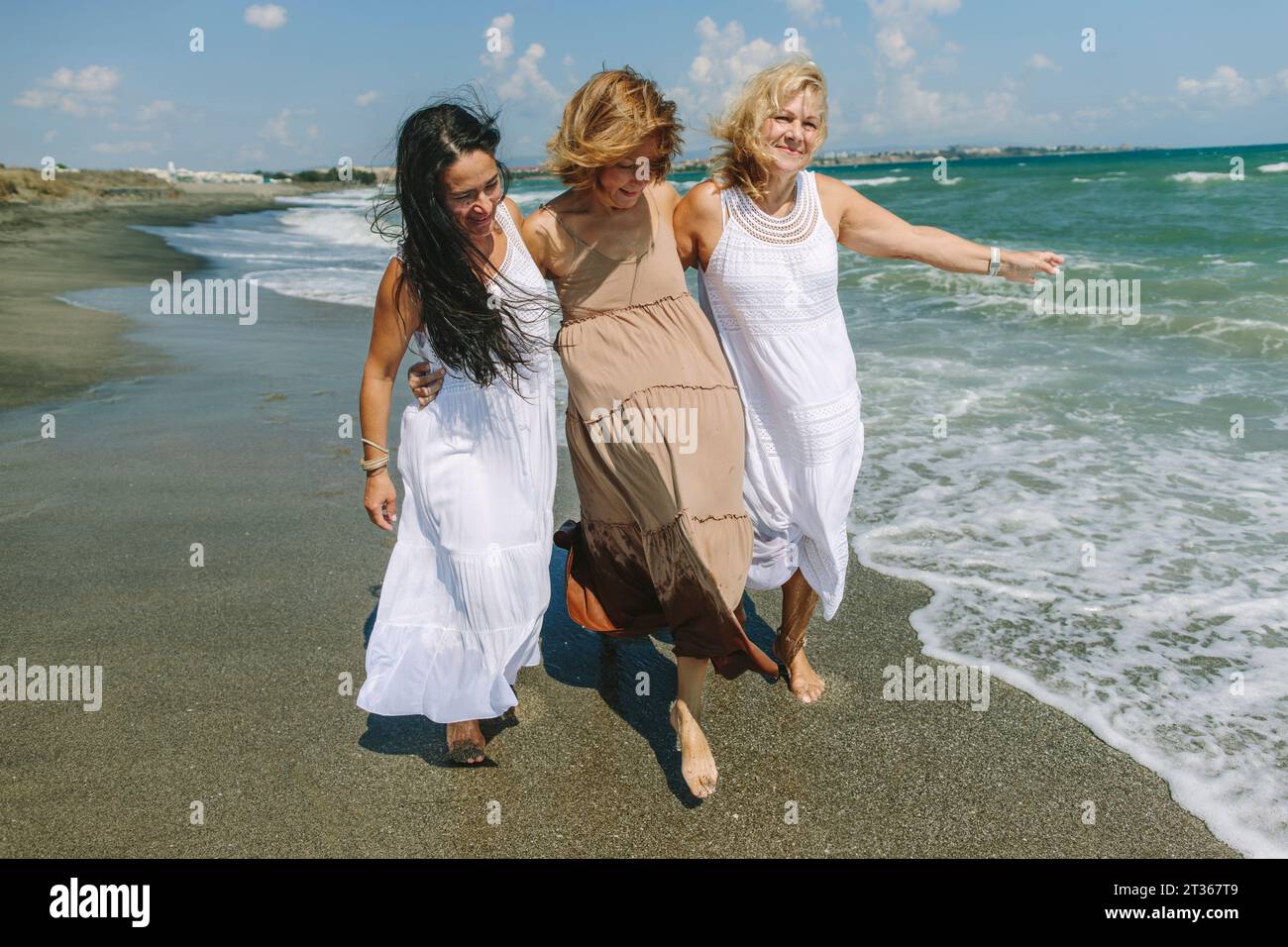 Women having fun walking together near shore at beach Stock Photo - Alamy