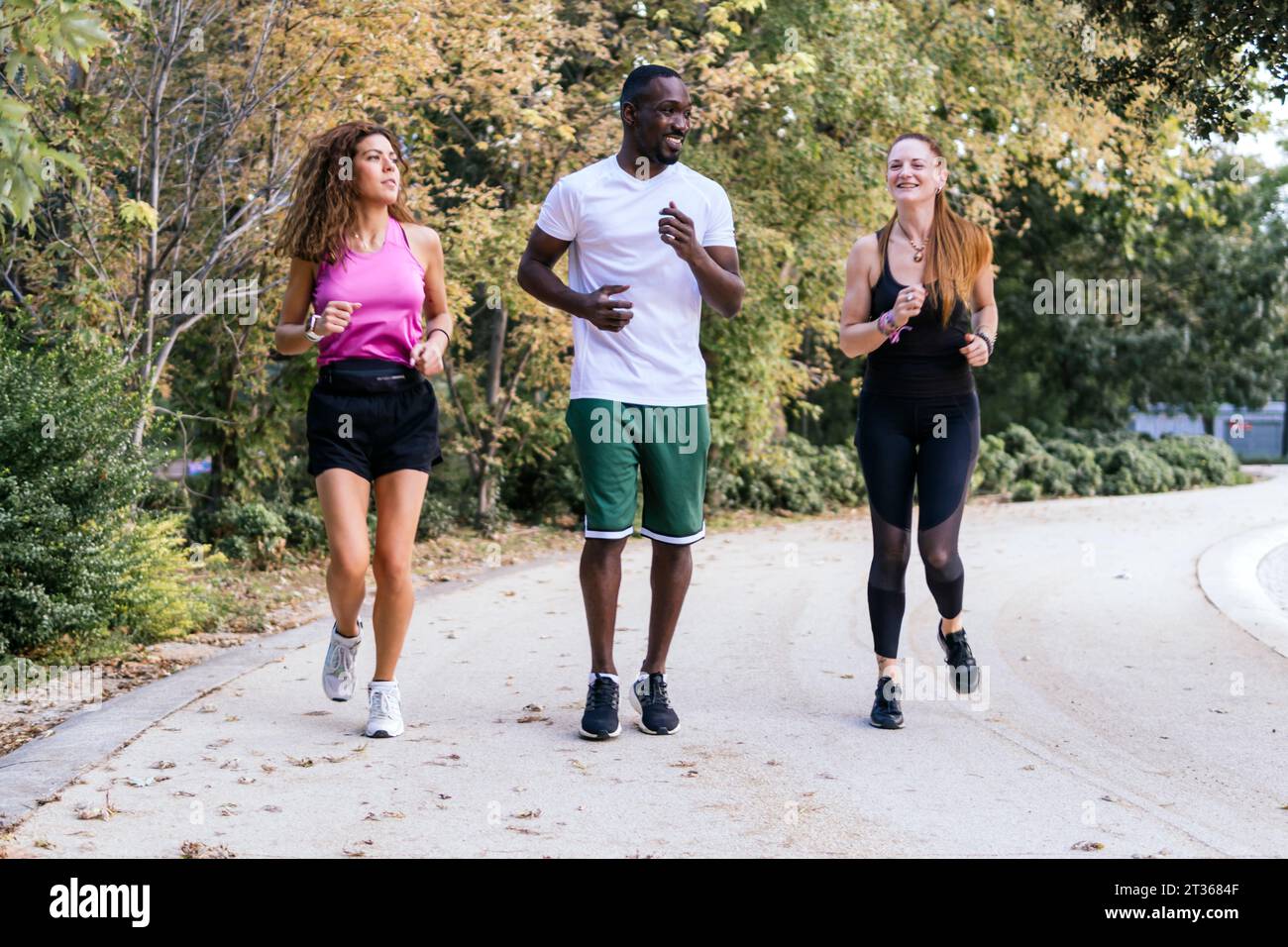 Happy multiracial friends running together at park Stock Photo - Alamy