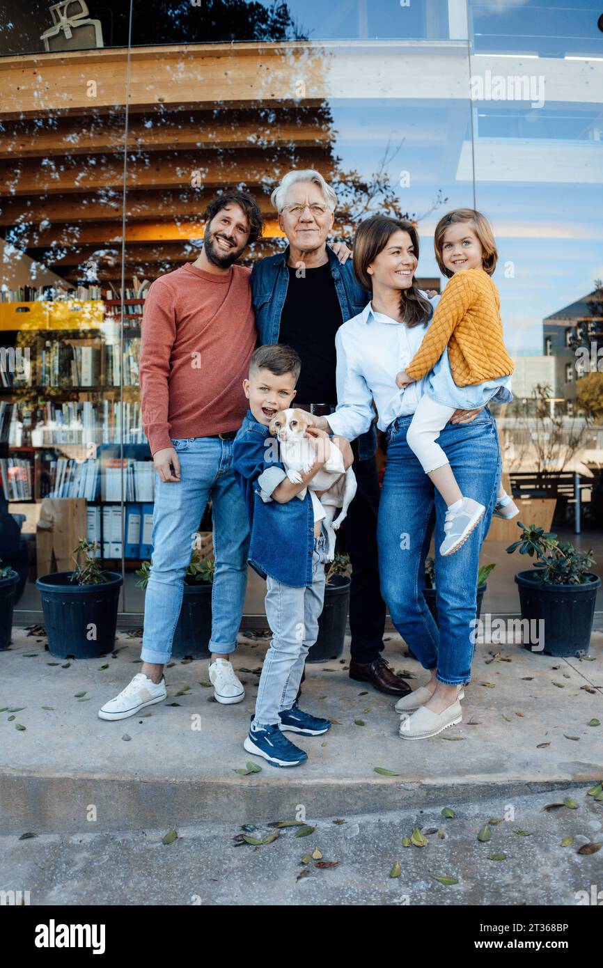 Happy family standing together in front of wall Stock Photo - Alamy