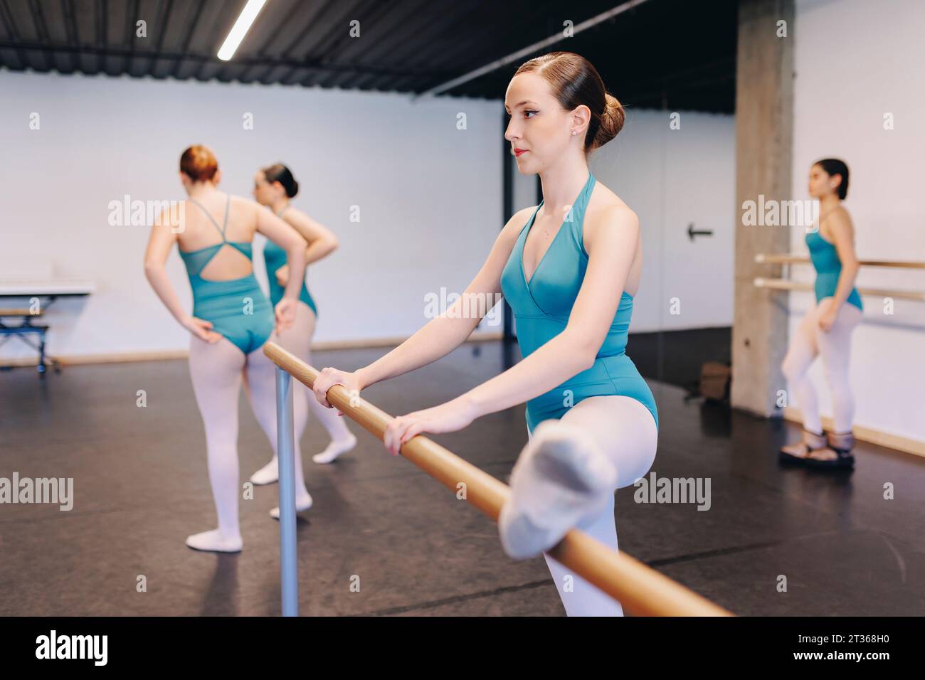 Ballet dancer doing stretching on railing in dance school Stock Photo ...