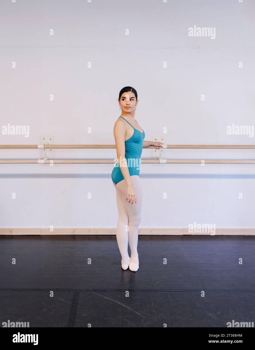 Girl wearing ballet costume standing near railing in dance school Stock ...