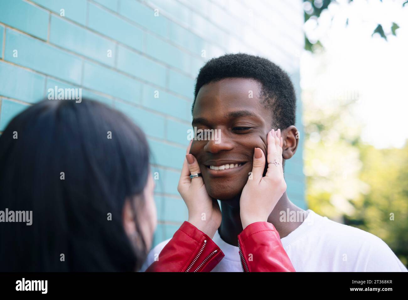 Woman pulling happy boyfriend's cheeks near wall Stock Photo - Alamy