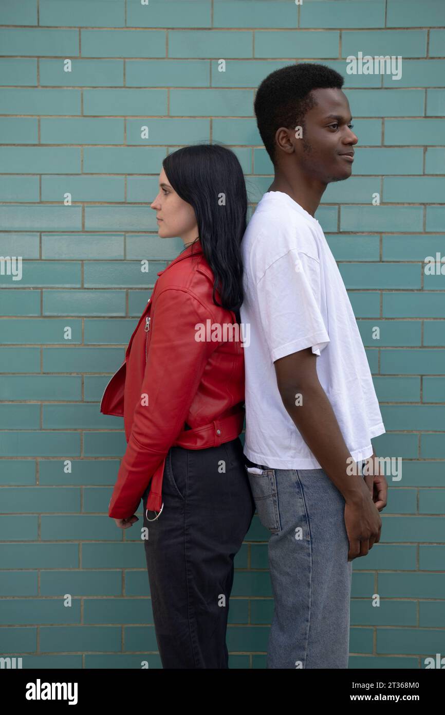 Smiling man and woman standing together in front of brick wall Stock ...