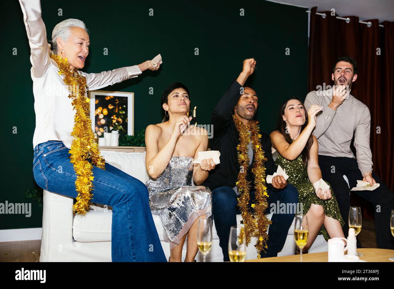 Happy multi-generation family cheering on sofa while celebrating new ...