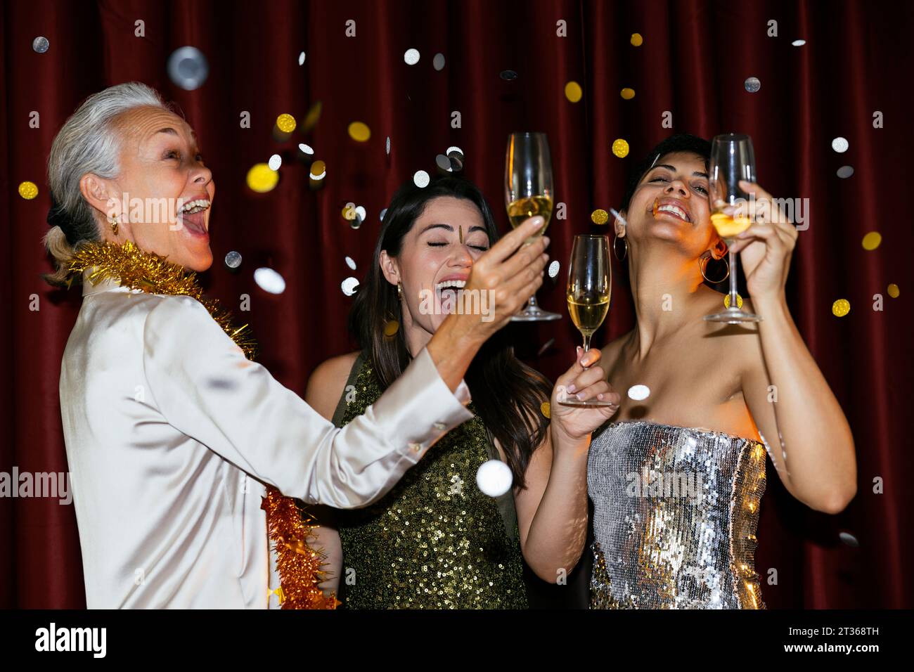 Happy women with champagne glasses enjoying dance at new year party ...