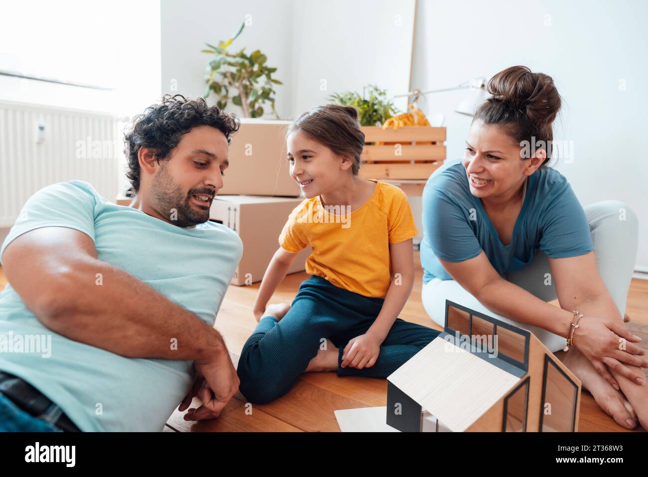 Happy family talking at model house at home Stock Photo - Alamy