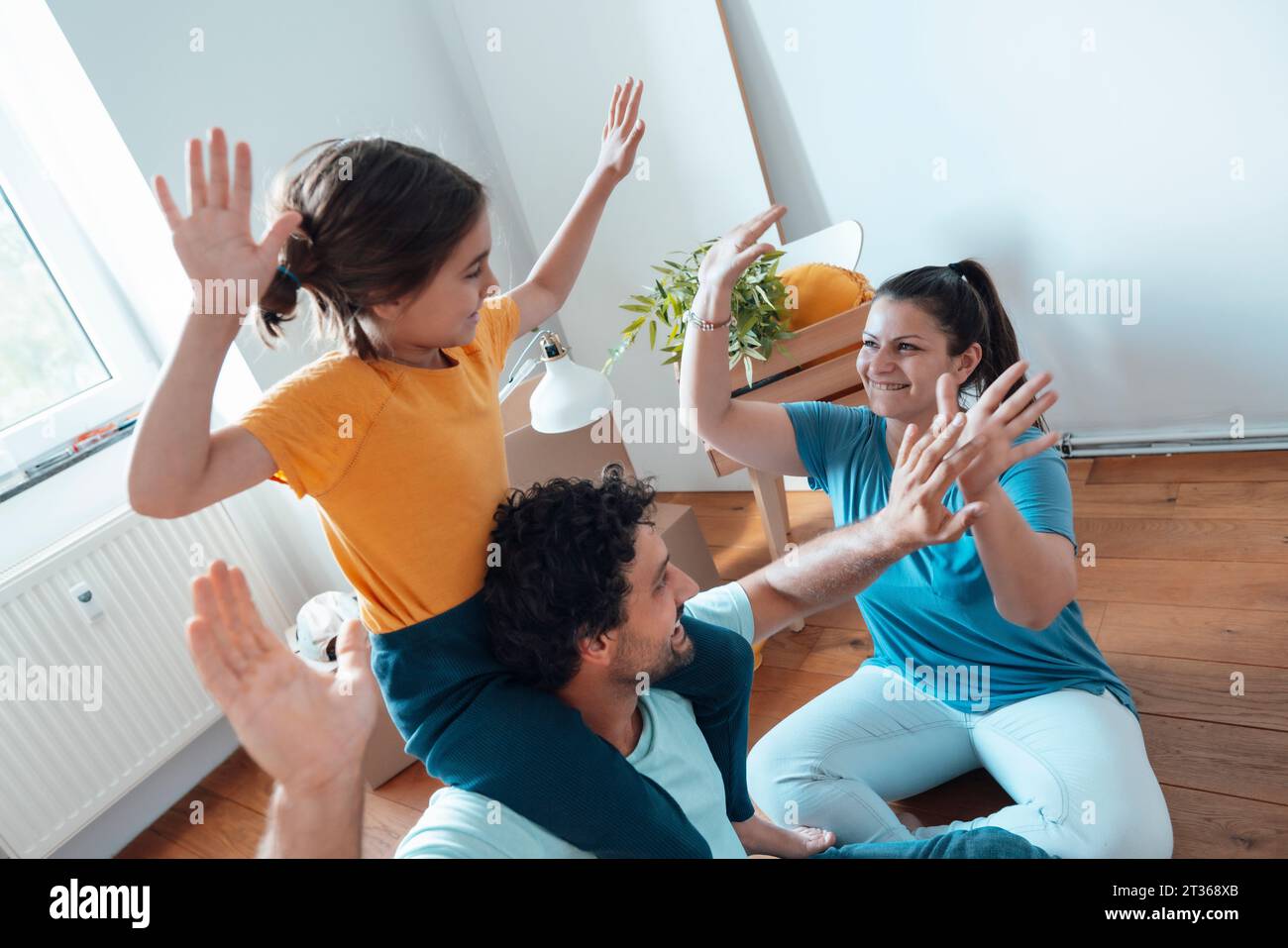 Happy family giving high-five to each other and having fun at home ...