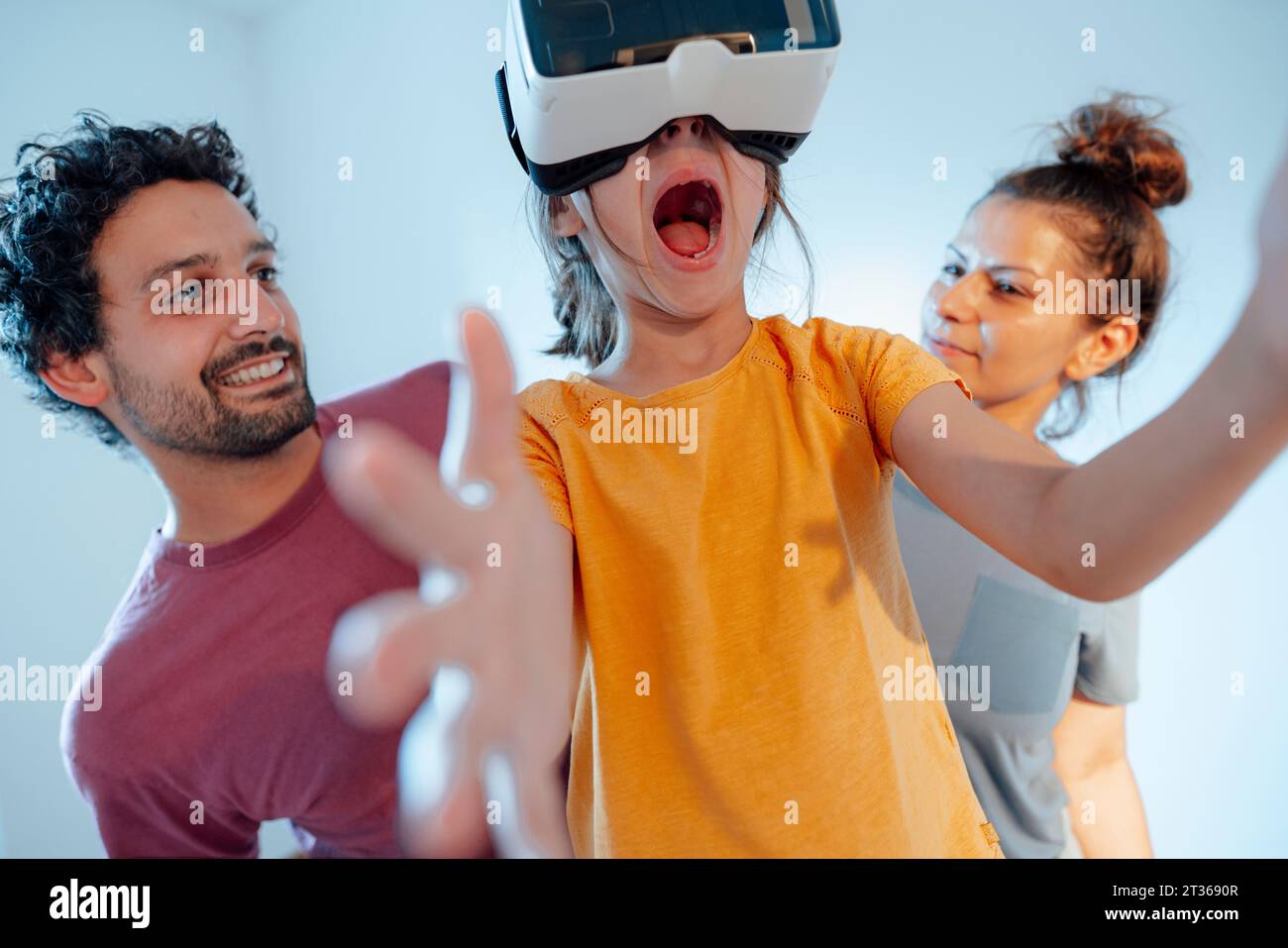 Happy man and woman with daughter wearing virtual reality simulators at ...