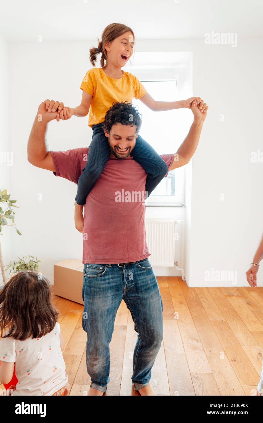 Happy father carrying daughter on shoulders at home Stock Photo - Alamy