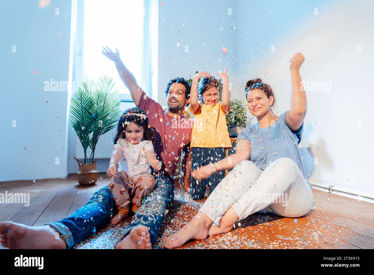 Happy family having fun with confetti at home Stock Photo - Alamy