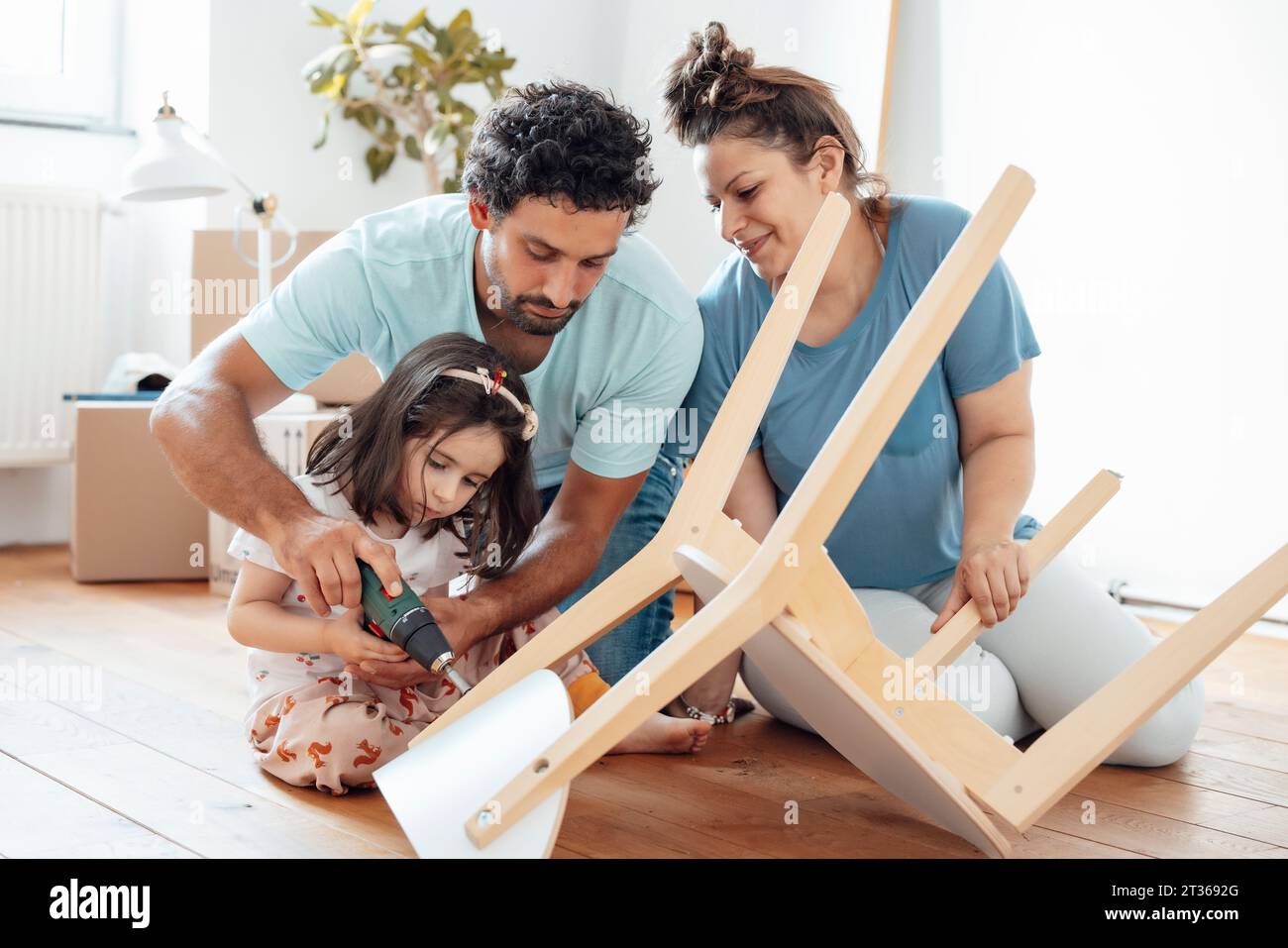Mother with father and daughter fixing chair at home Stock Photo - Alamy