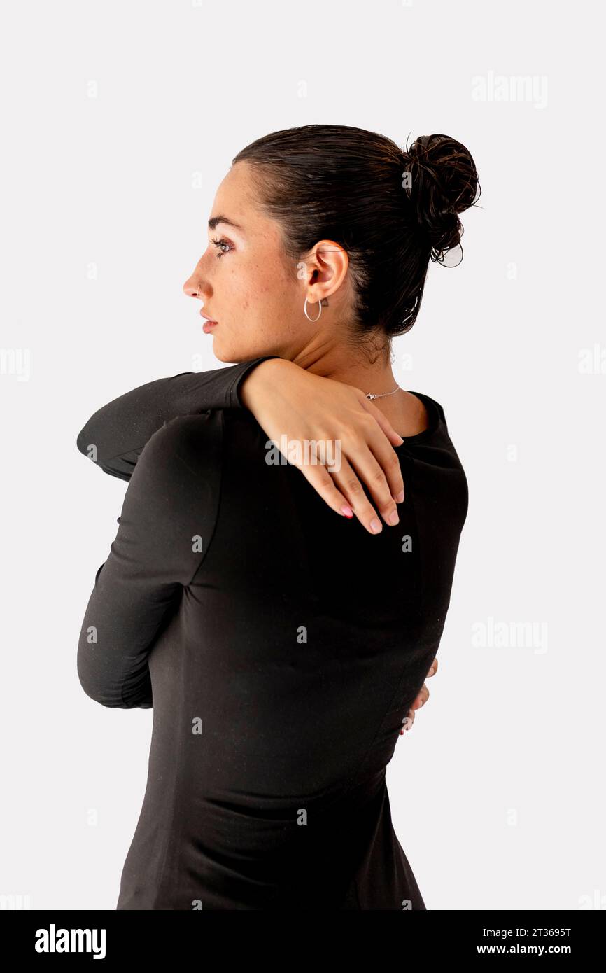 Woman hugging self against white background Stock Photo - Alamy