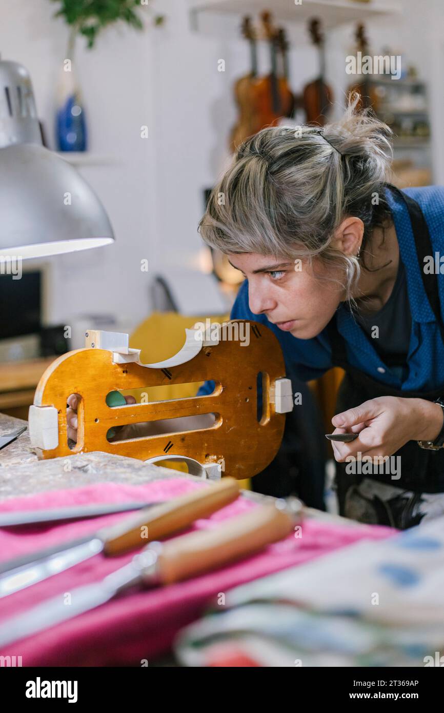Luthier working on violin in musical instrument workshop Stock Photo ...