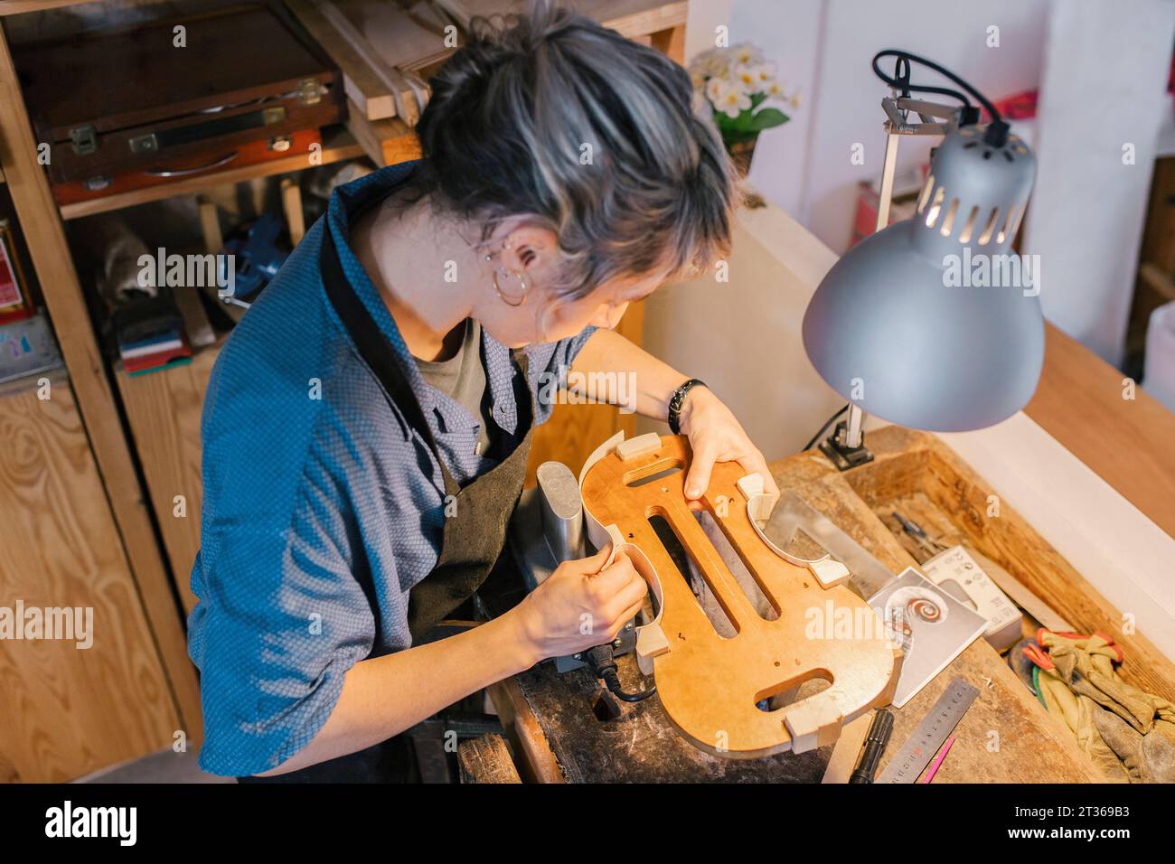 Luthier making parts of violin on desk in workshop Stock Photo - Alamy